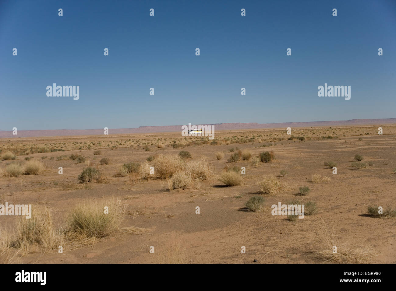 Bus on a road crossing the Sahara desert near the village of Gfafate in ...