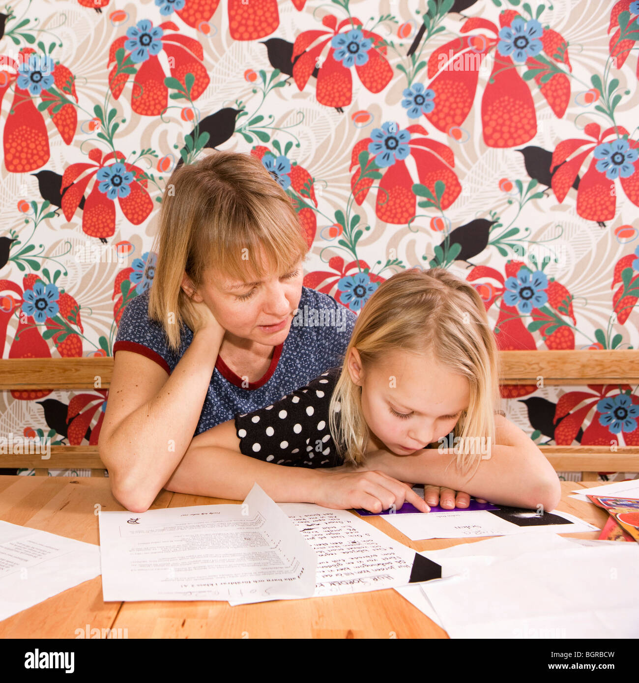 Woman helping girl with homework, Sweden Stock Photo - Alamy