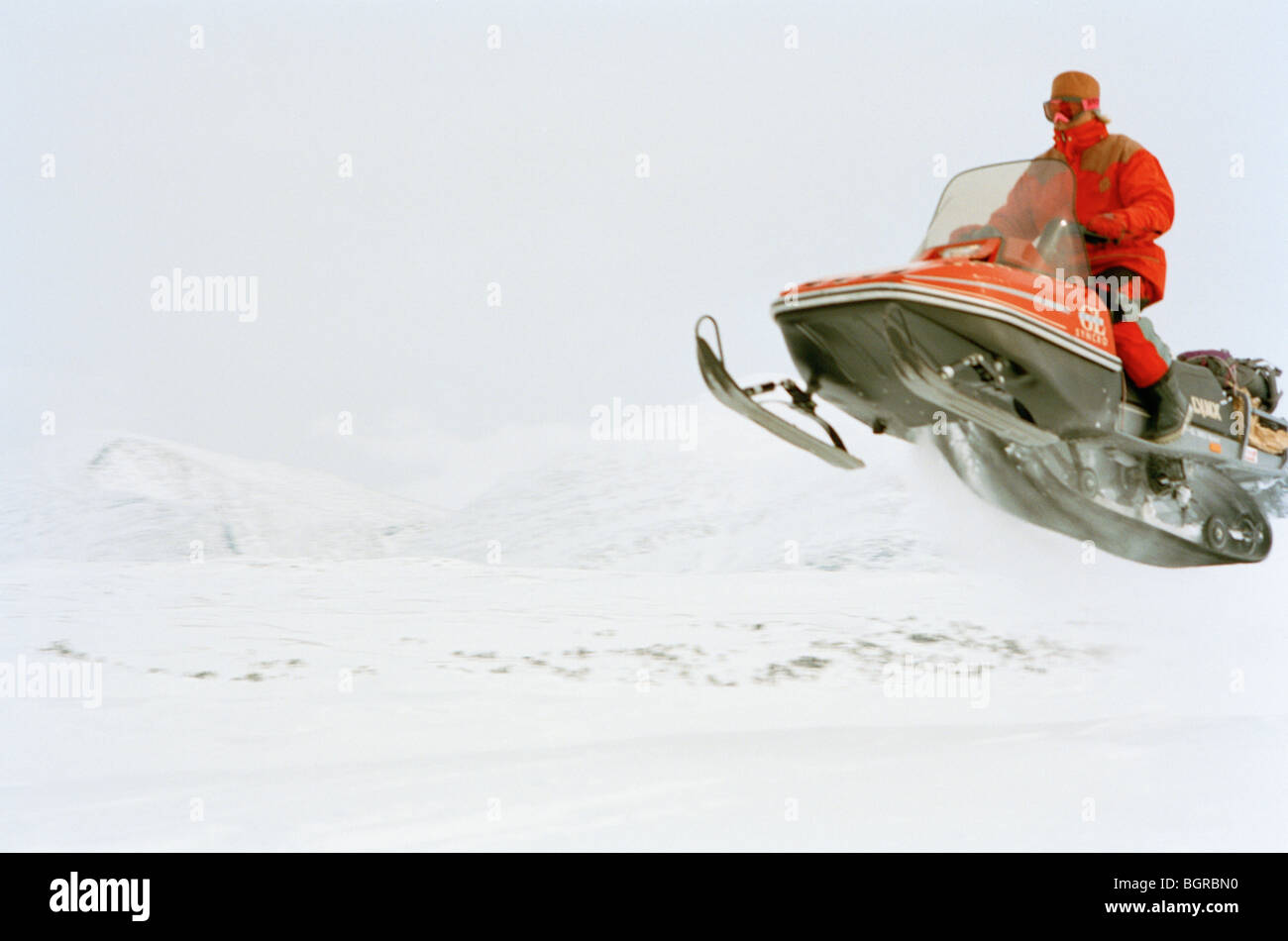 A man jumping with a snowmobile Stock Photo - Alamy