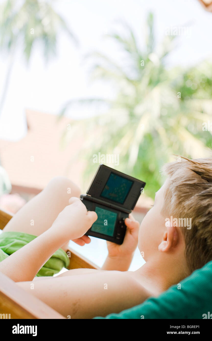 Boy playing a computer game, the Maldives Stock Photo - Alamy