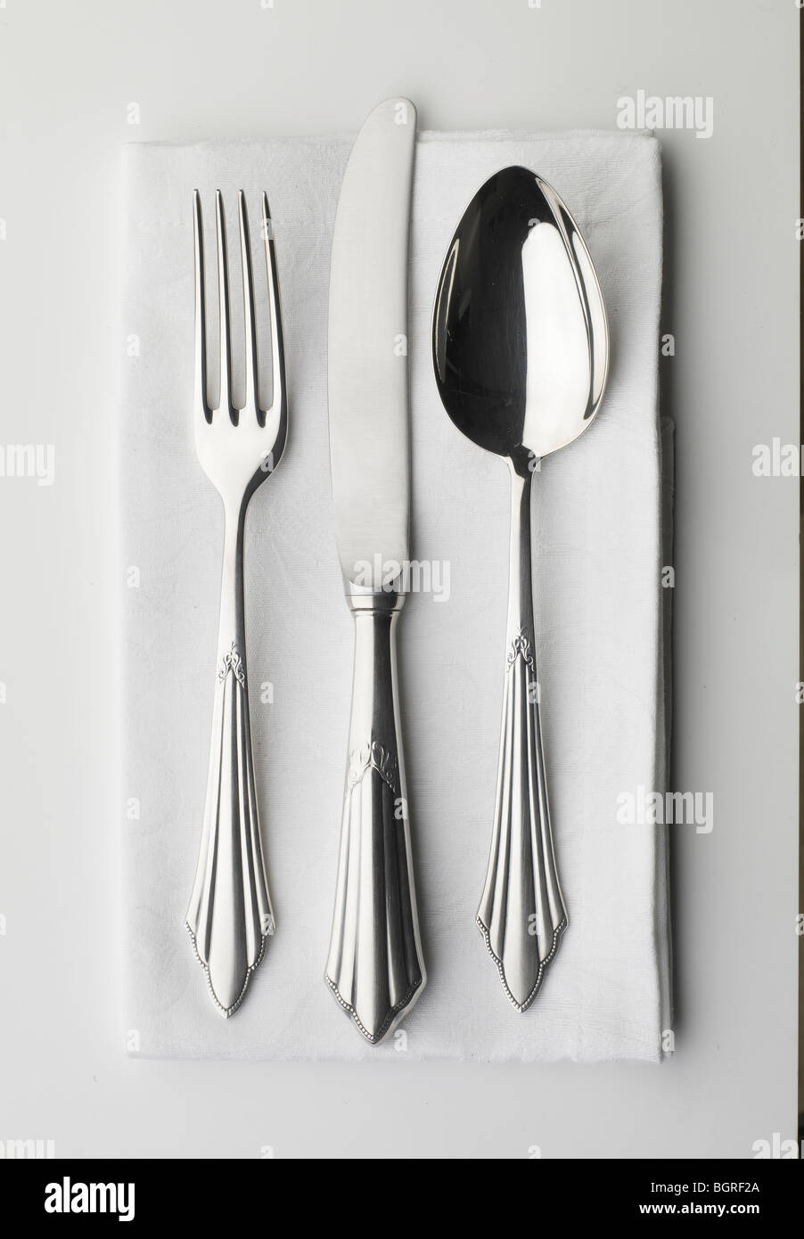 Silver cutlery on a white serviette Stock Photo - Alamy