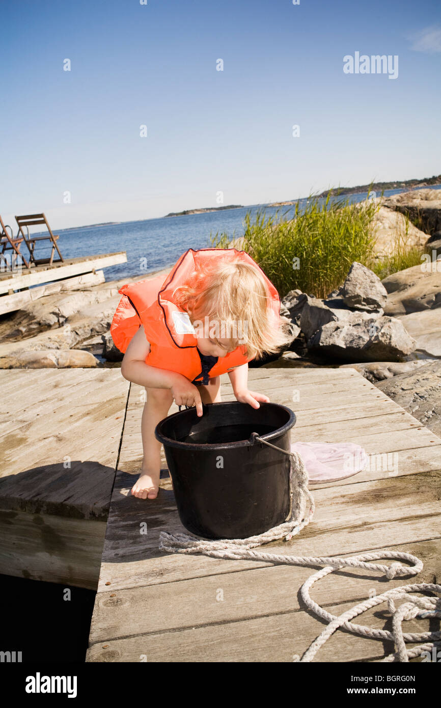 Boy looking looking at newly caught fish in a bucket, Sweden Stock ...