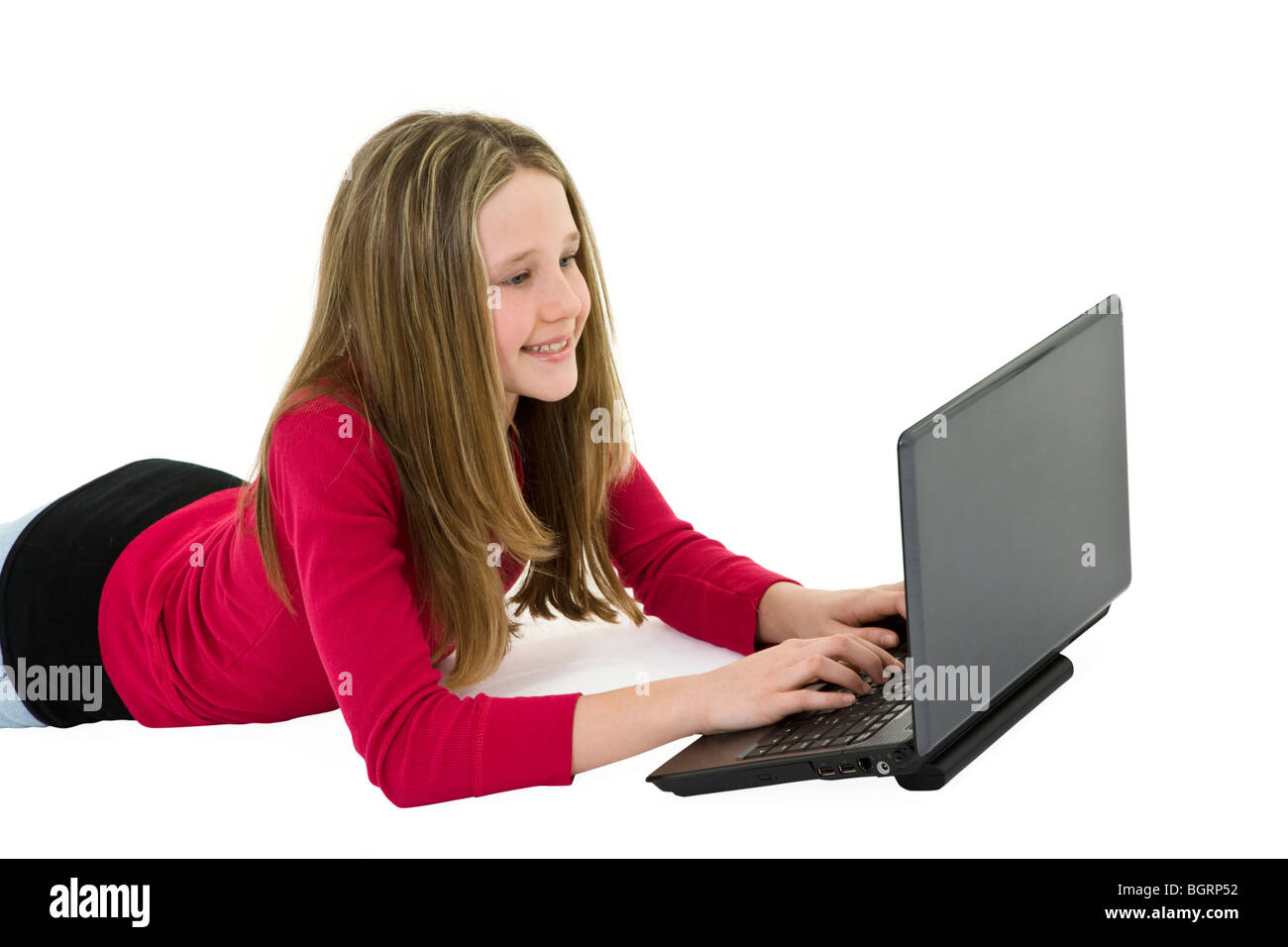 Child laying on a white background working on laptop computer Stock ...