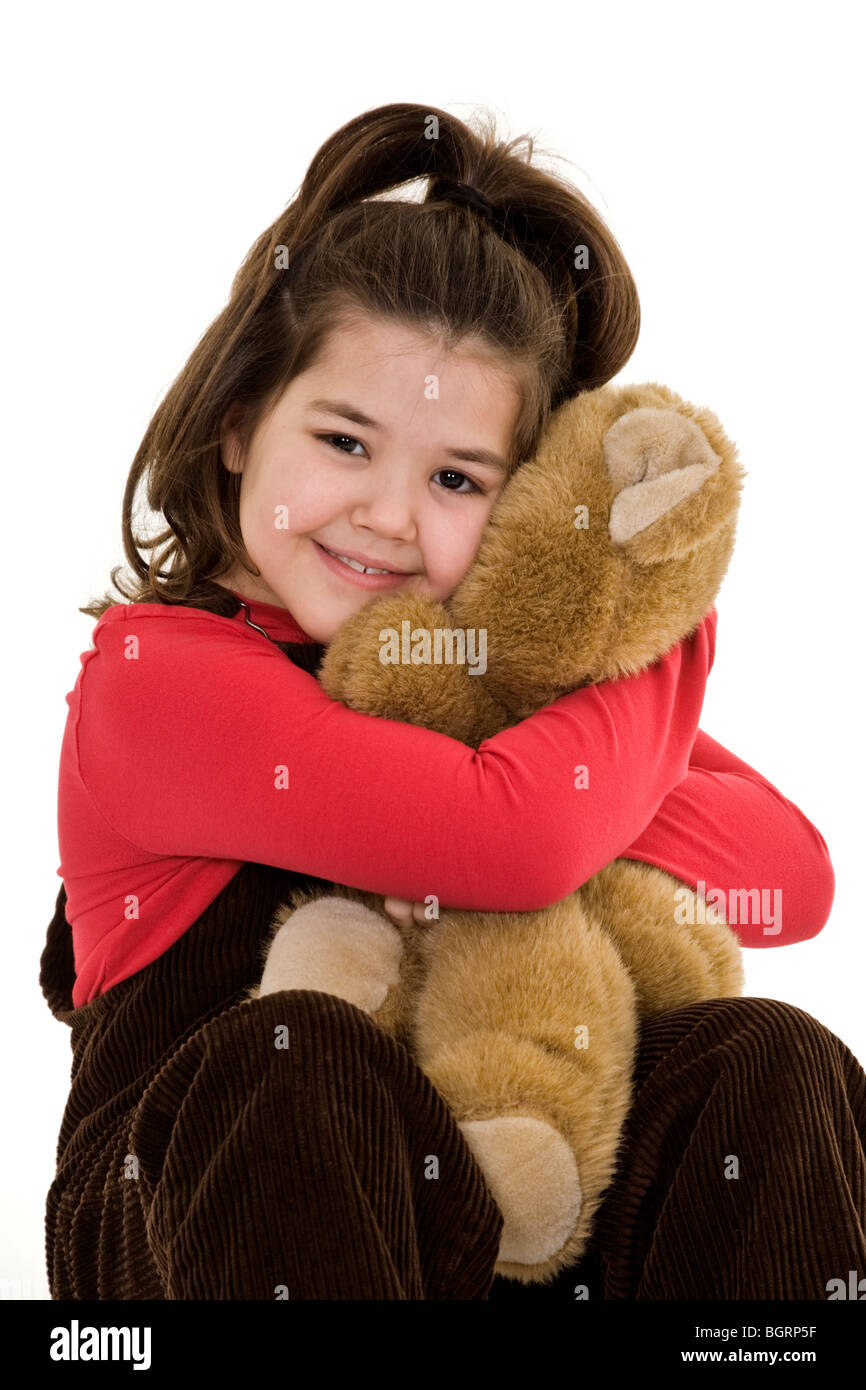 Caucasian child hugging a teddy bear with a big smile on her face. She ...