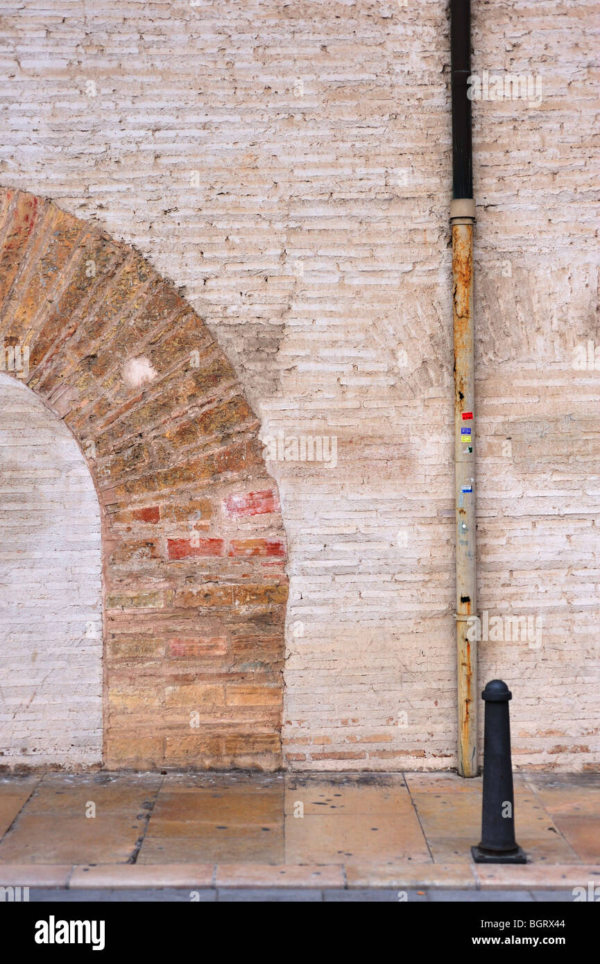 on the left, a half arch of stone on a stone wall on the right a ...