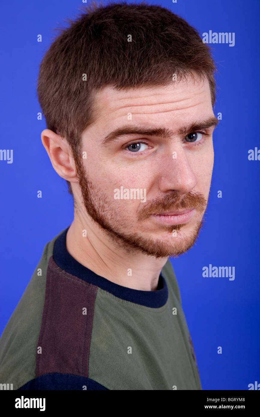 an young man portrait over a blue background Stock Photo - Alamy