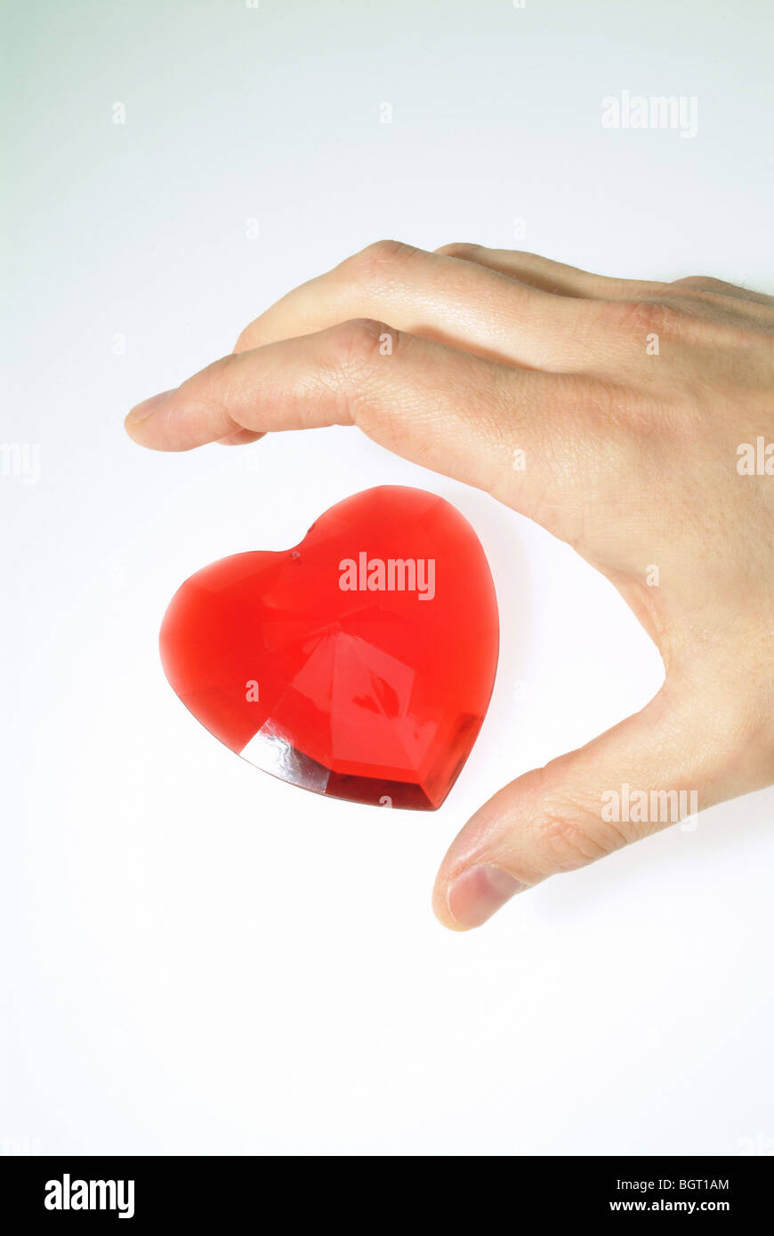 Hand reaching for a plastic heart Stock Photo - Alamy