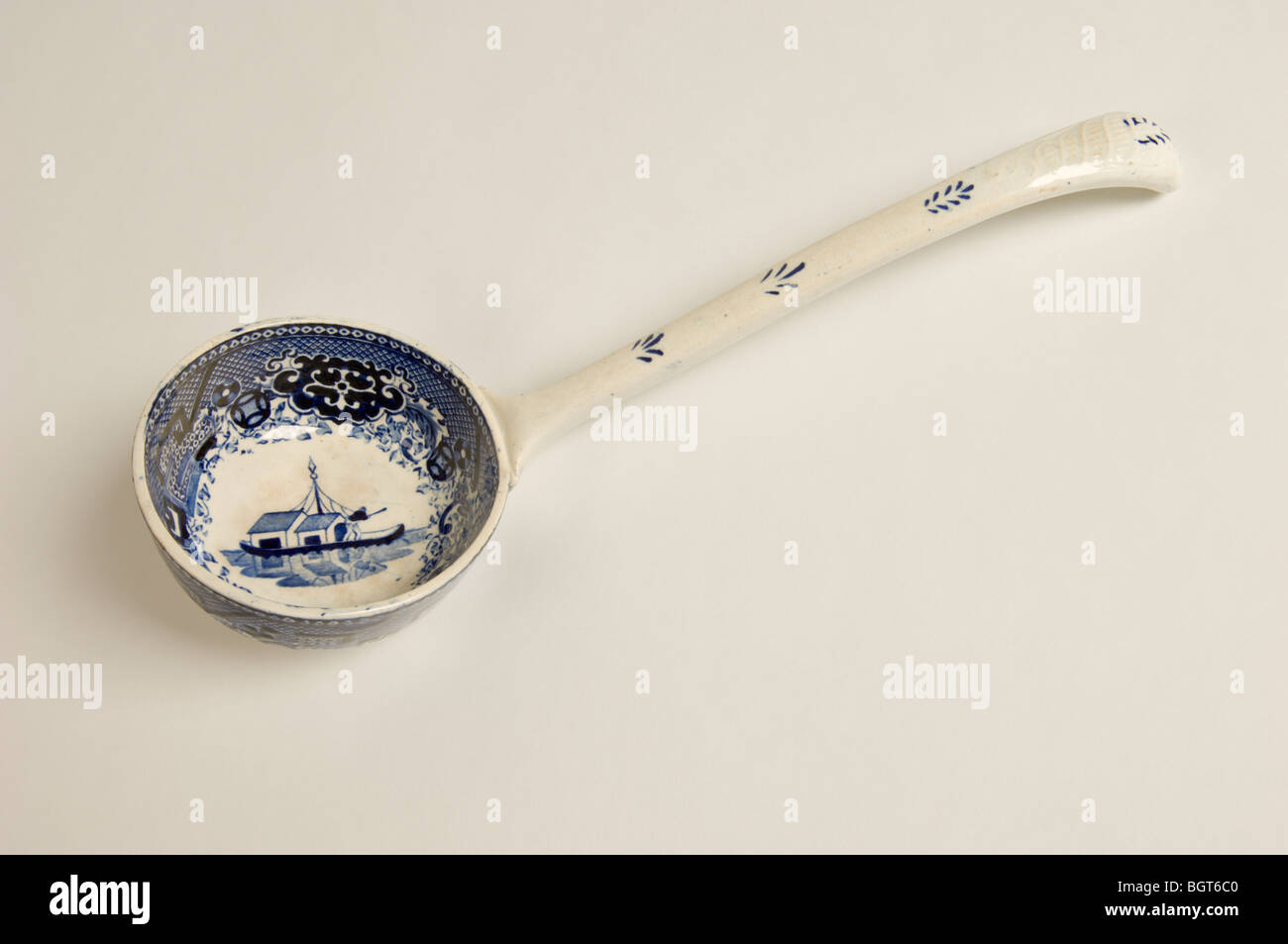 A blue and white pottery ladle decorated with transfer prints, probably ...
