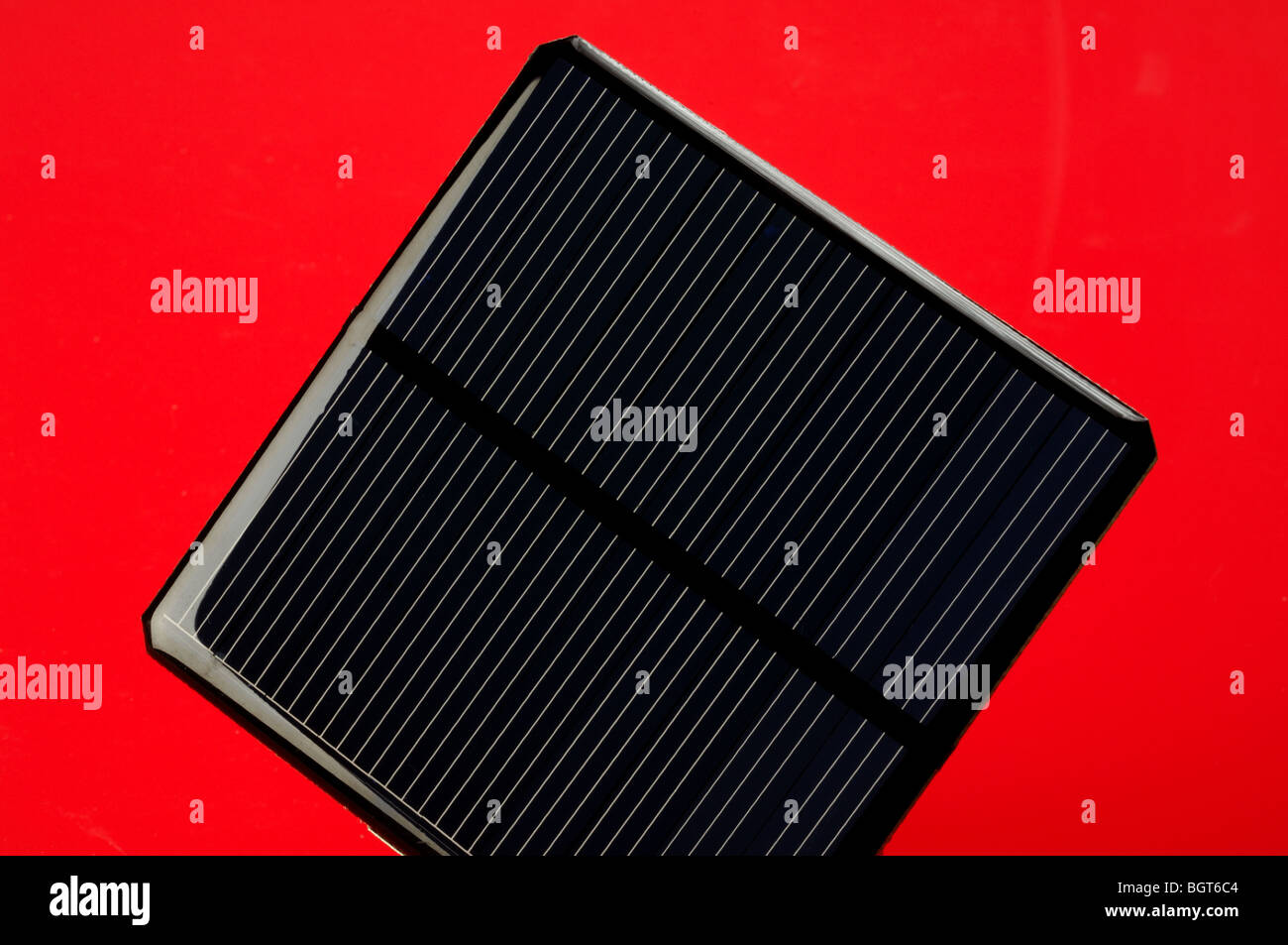 A square solar panel on a red background Stock Photo - Alamy