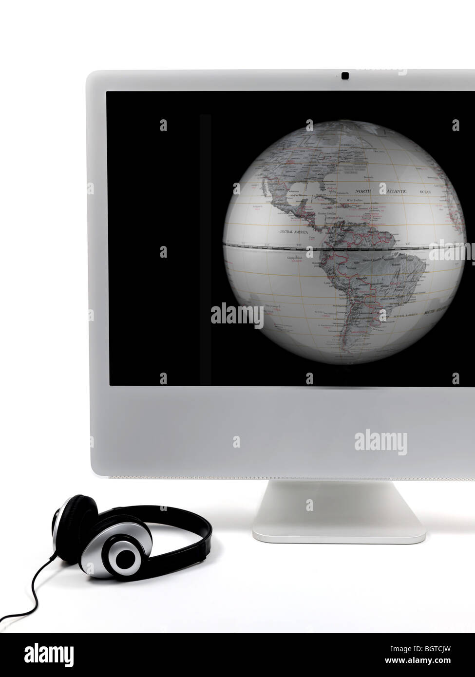A desktop computer with a set of headphones isolated against a white ...