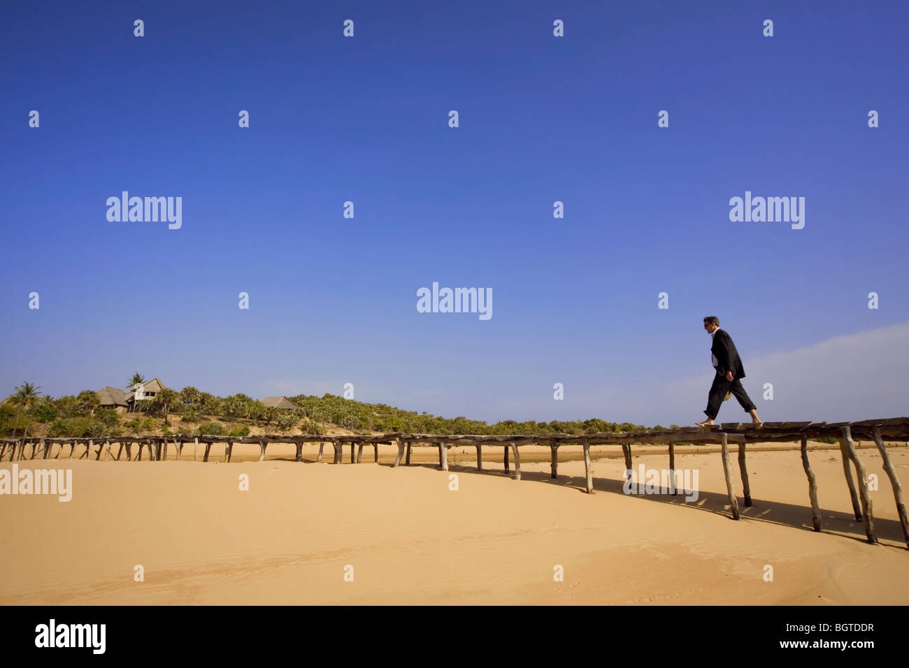 Businessman on raised boardwalk above beach, Lamu Island, Kenya Stock ...