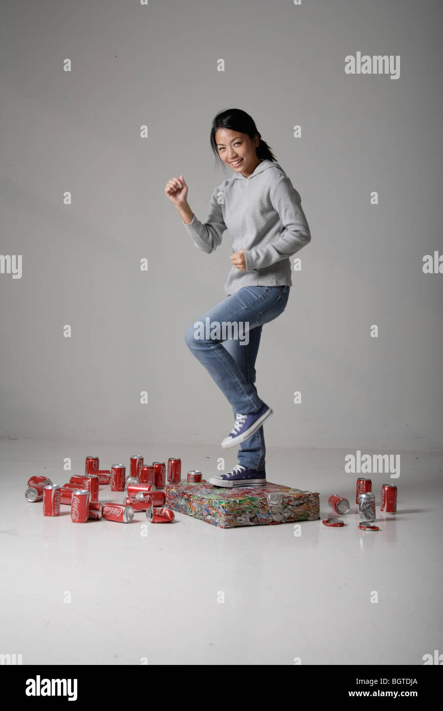 Young Asian woman jumping on cans Stock Photo - Alamy