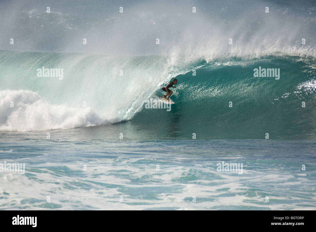 A sufer rides a large wave, inside the barrel, at Pipeline, North Shore ...