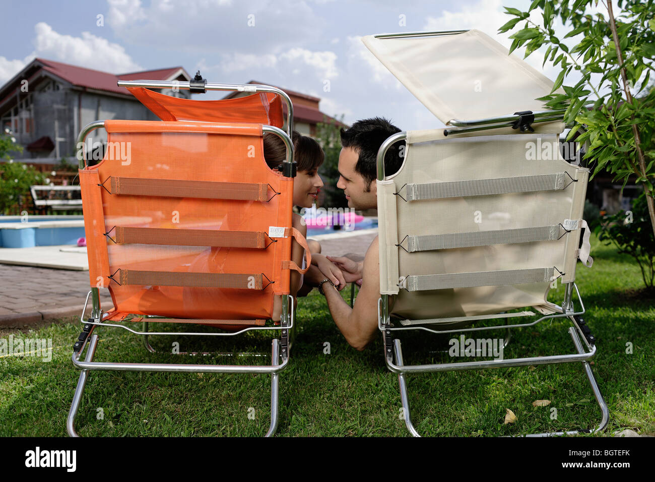 man and woman sitting by the swimming pool Stock Photo - Alamy