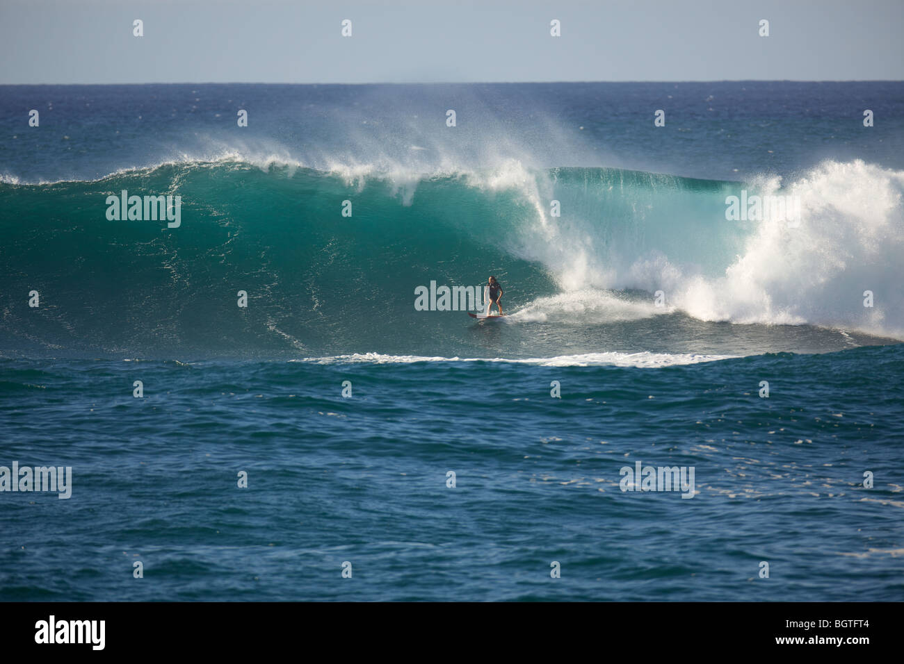 A surfer rides a large wave at Waimea Bay, North Shore, Oahu, Hawaii ...