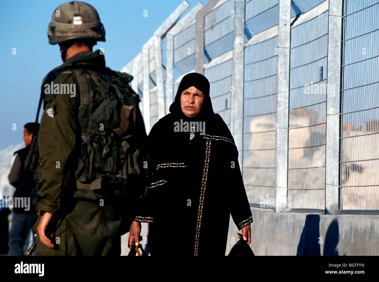 A Palestinian woman makes her way through the checkpoint at Kalandia ...