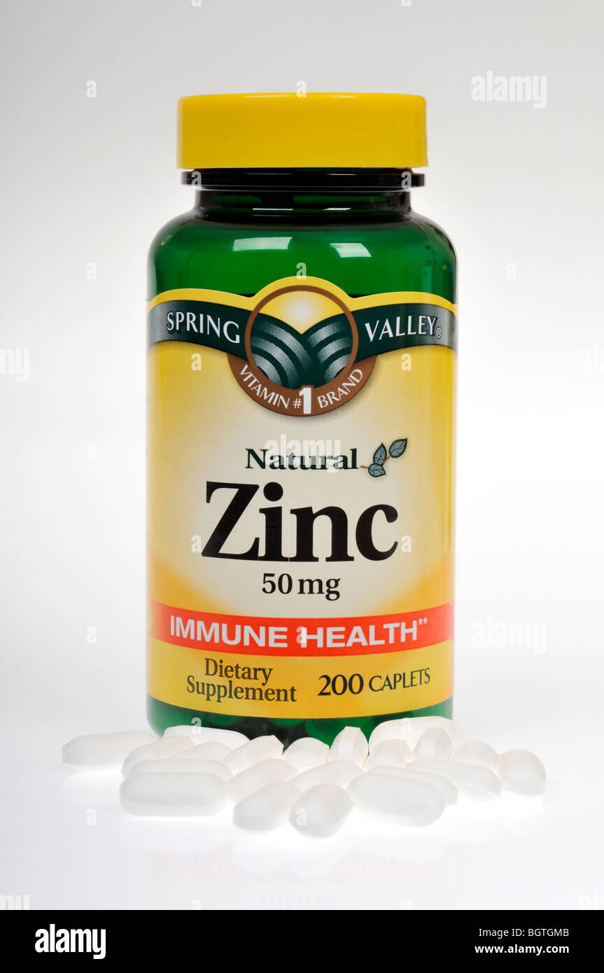 White caplets and bottle of Zinc dietary supplement on white background ...
