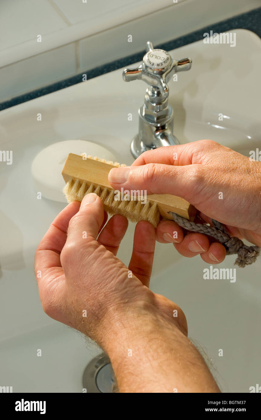 Close up of man cleaning scrubbing his fingernails with a nailbrush in ...