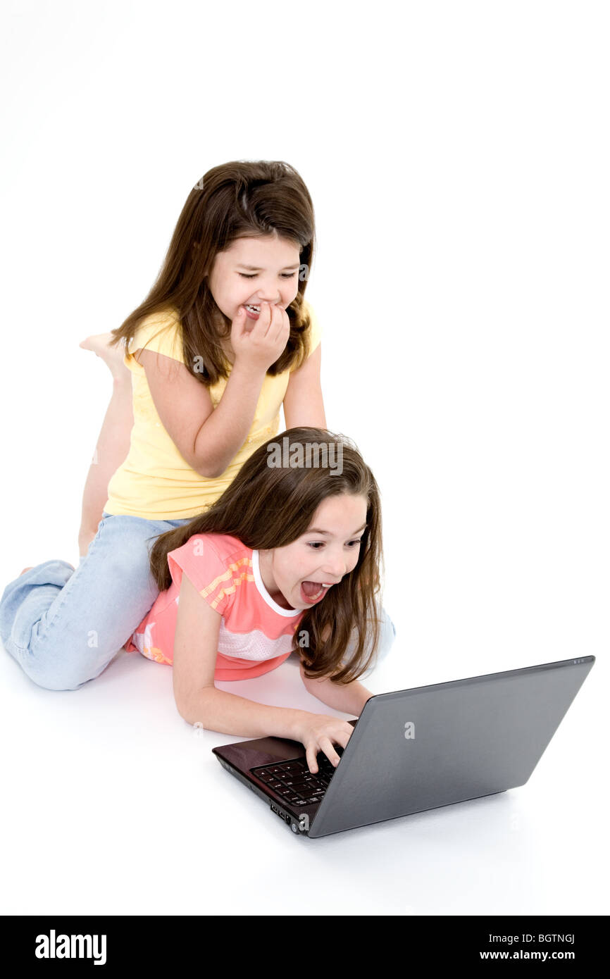 Sisters playing on a laptop computer on a white background Stock Photo ...