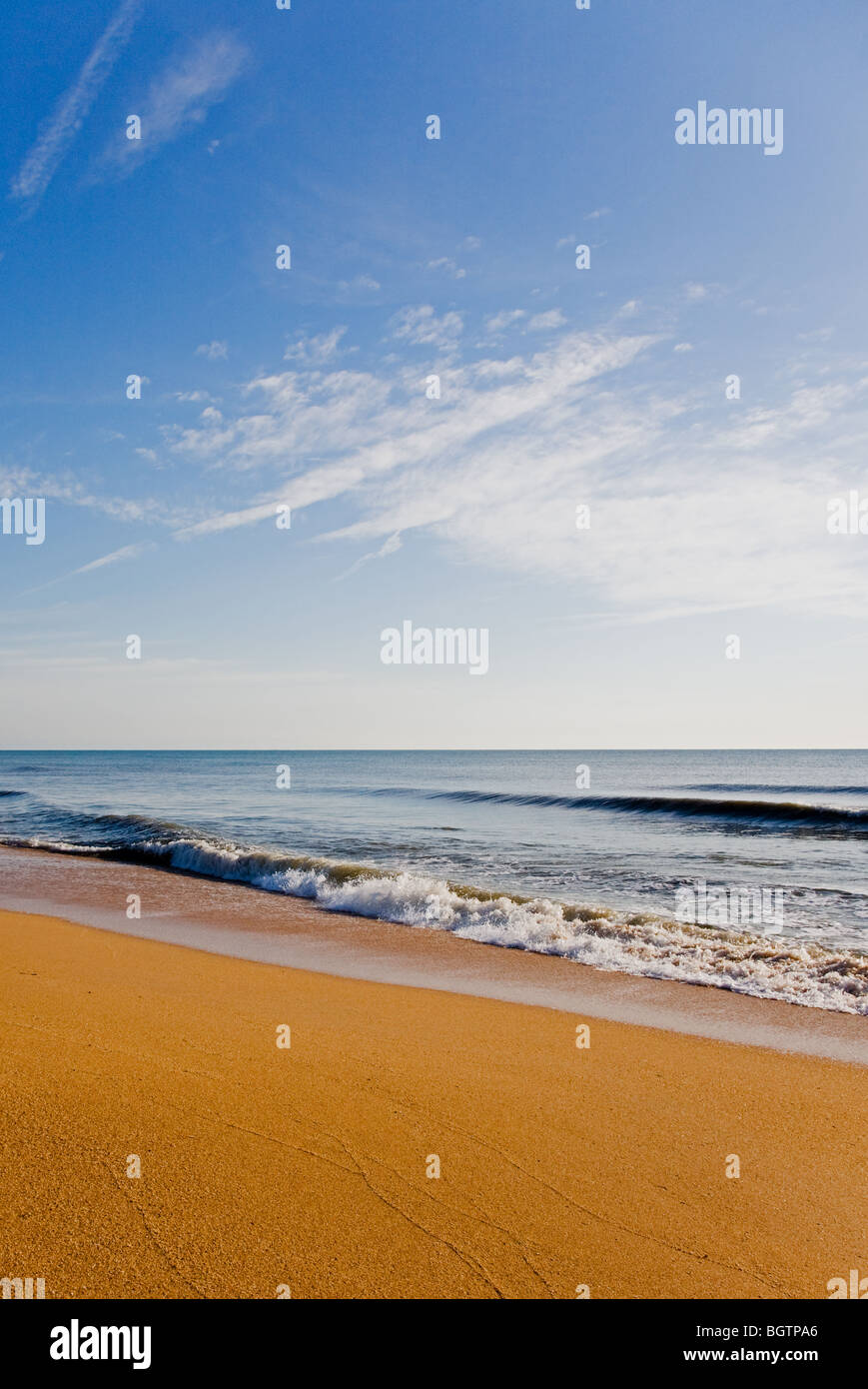 Early morning light on the rich colored sand and surf of the beach ...