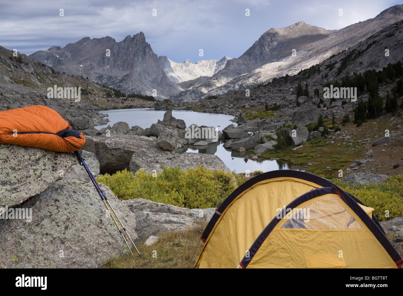 Camping in wilderness. Tent and sleeping bag overlooking mountains ...