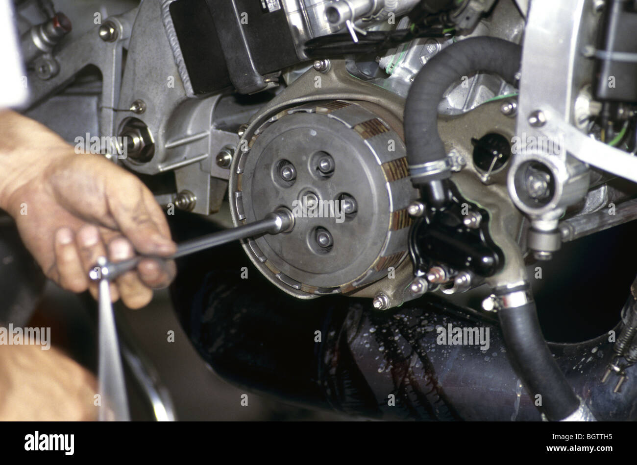 Mechanic works on motorcycle engine in pits Stock Photo - Alamy