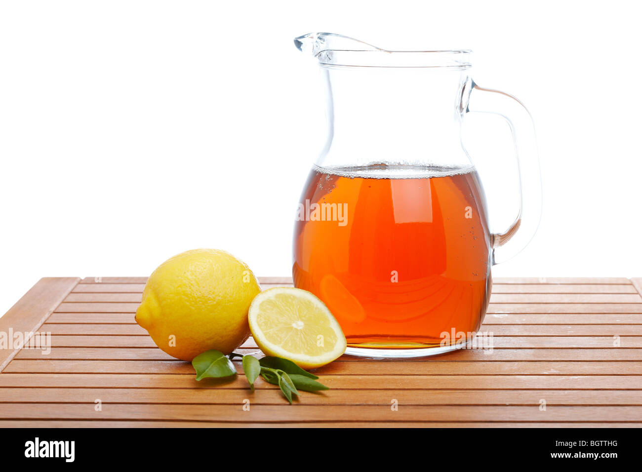 Ice tea pitcher with lemon and icecubes on wooden background Stock ...