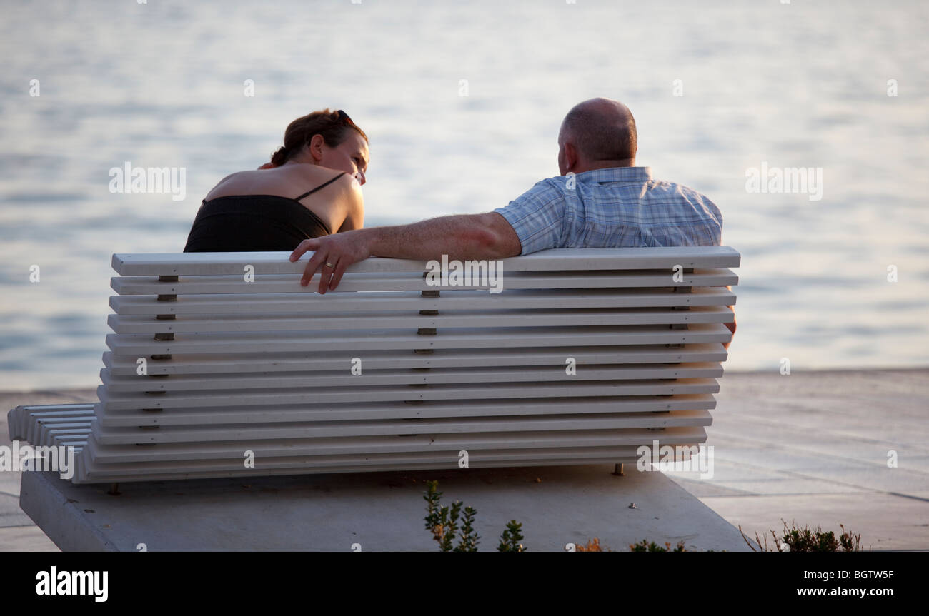 couple sitting on bench Stock Photo - Alamy