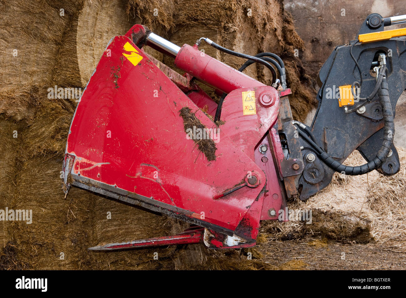 Shear grab at silage pit face cutting a section of silage. This keeps ...