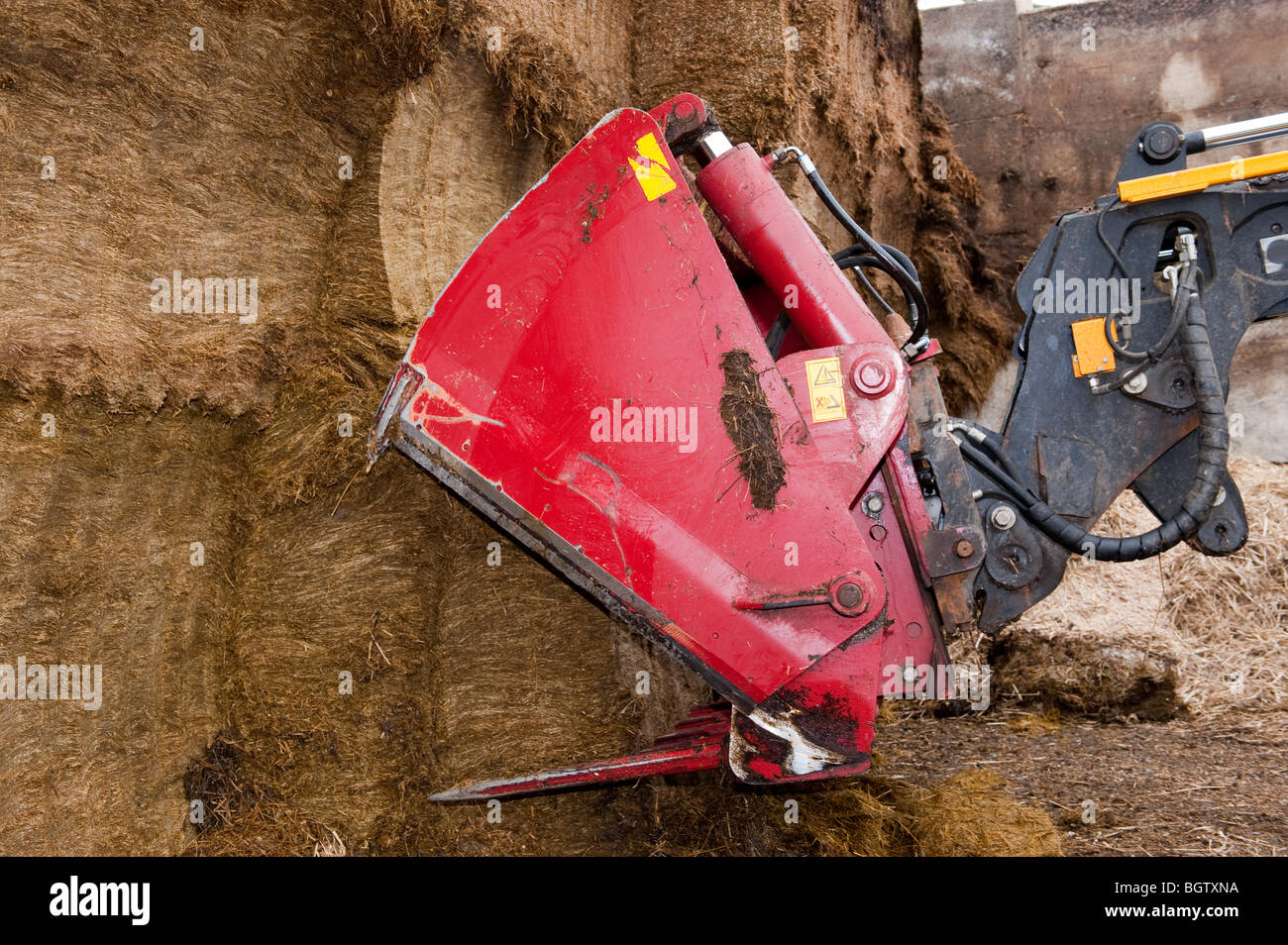 Shear grab at silage pit face cutting a section of silage. This keeps ...