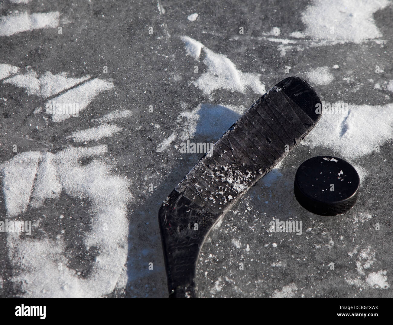 Ice hckey stick and puck on frozen ice Stock Photo - Alamy