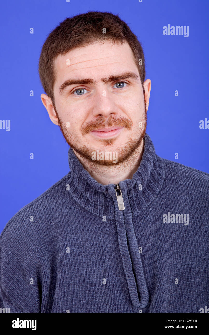 an young man portrait over a blue background Stock Photo - Alamy