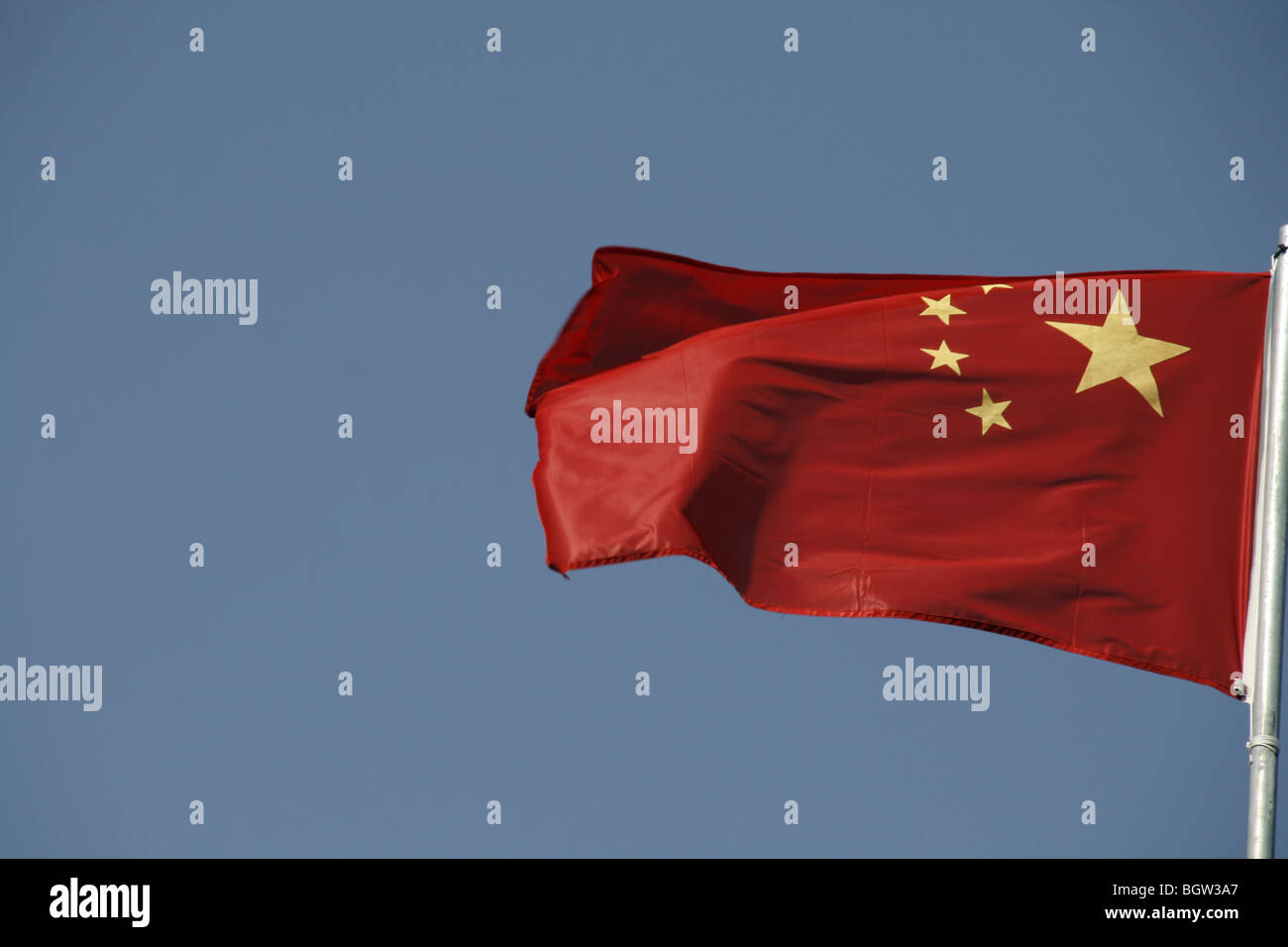 one chinese flag flying in wind and blue sky Stock Photo - Alamy