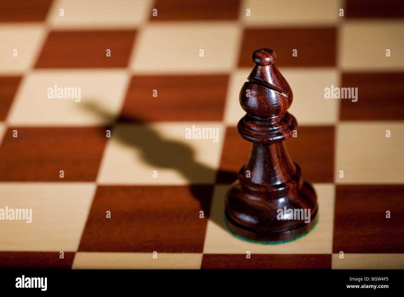 Chess piece - a black bishop on a chessboard Stock Photo - Alamy