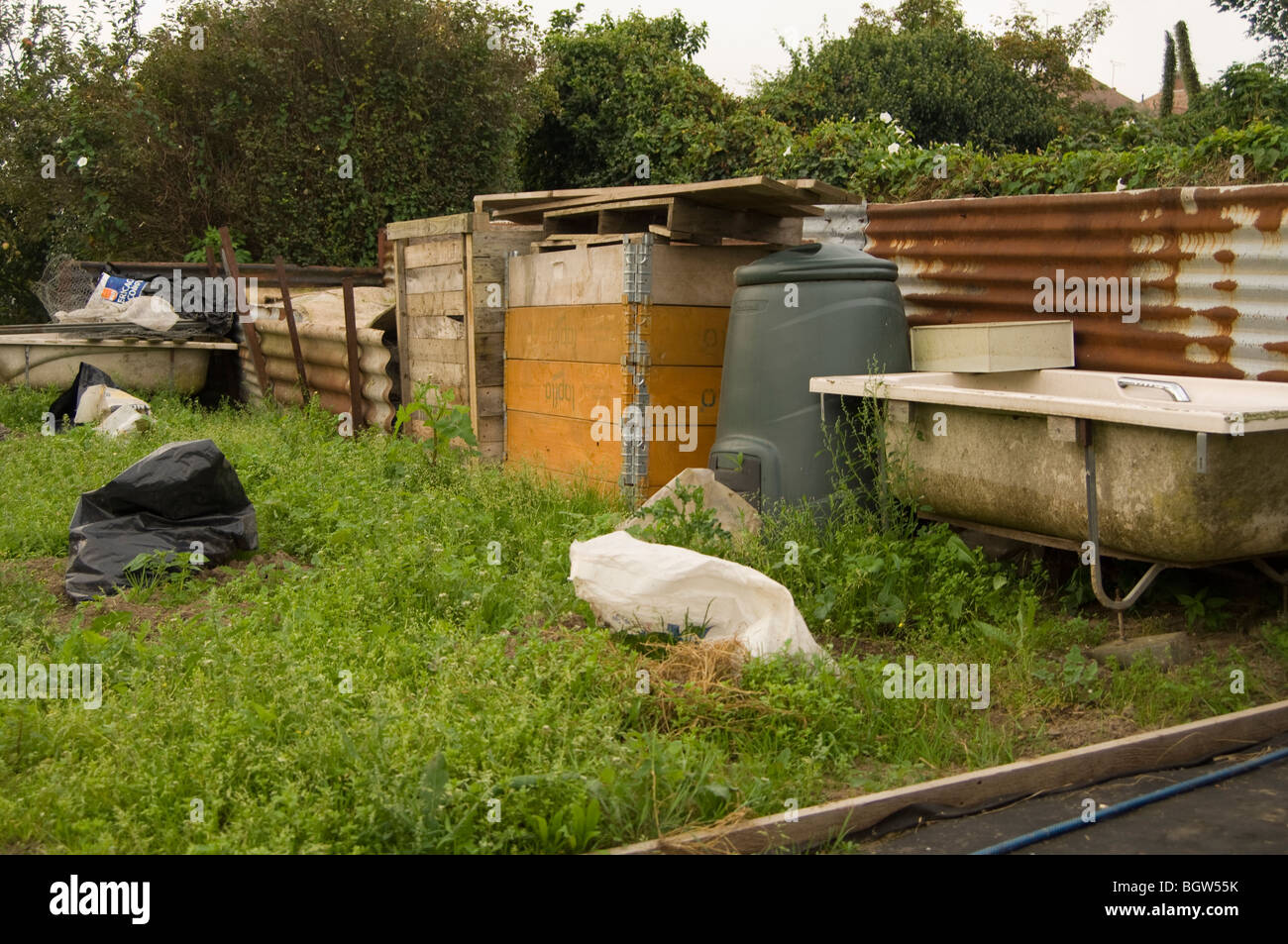 Composting area of an allotment plot showing various compost bins and ...