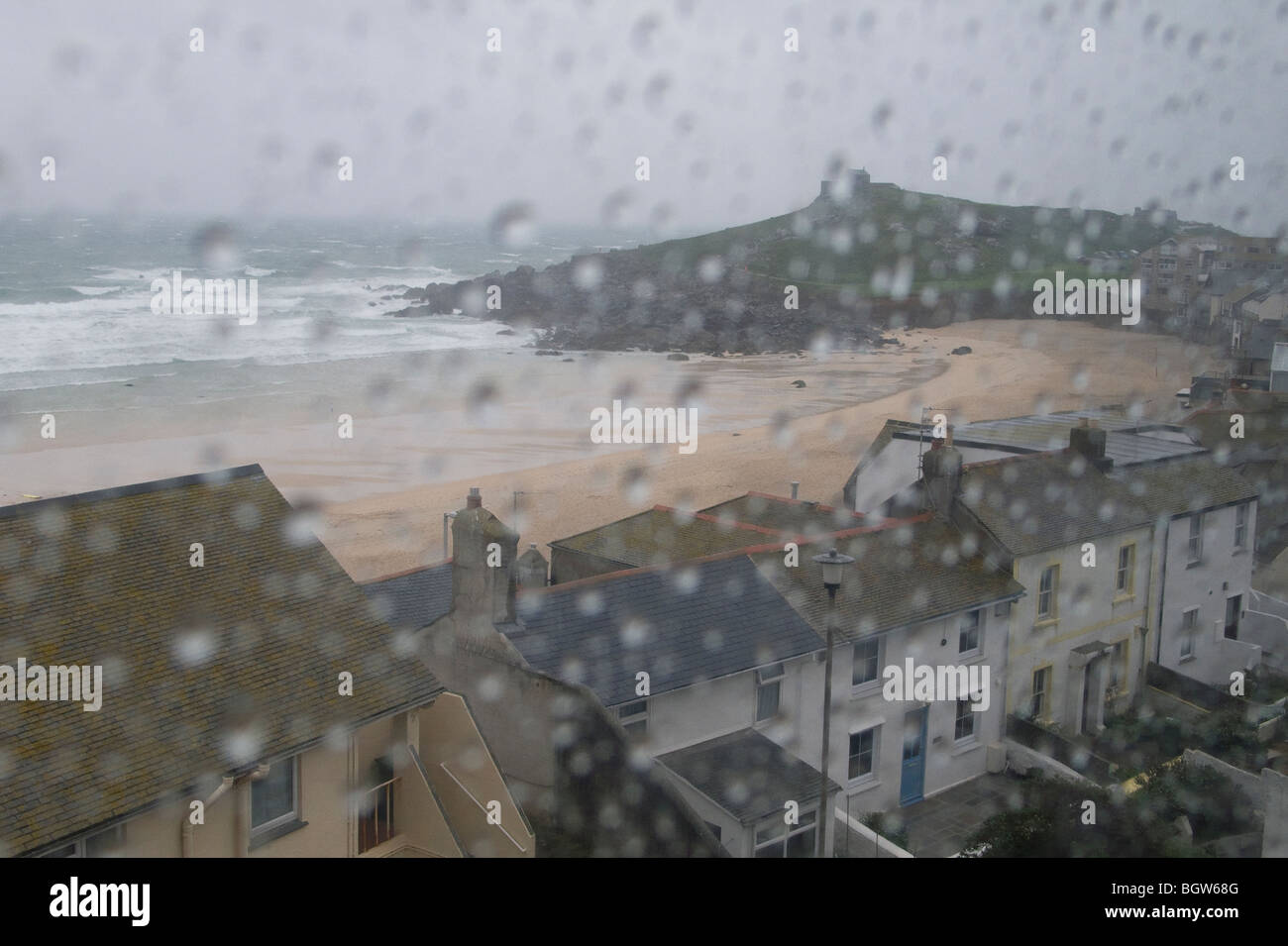 Looking through a rain splattered window pane at a rainy grey day ...