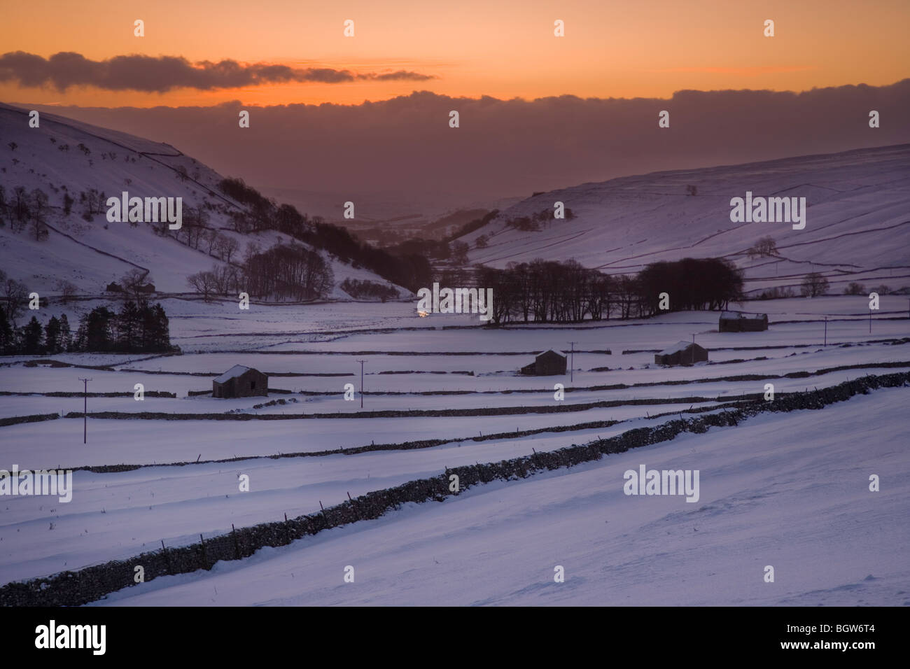 Sunrise over typical snow covered Yorkshire Dales scenery with Drystone ...