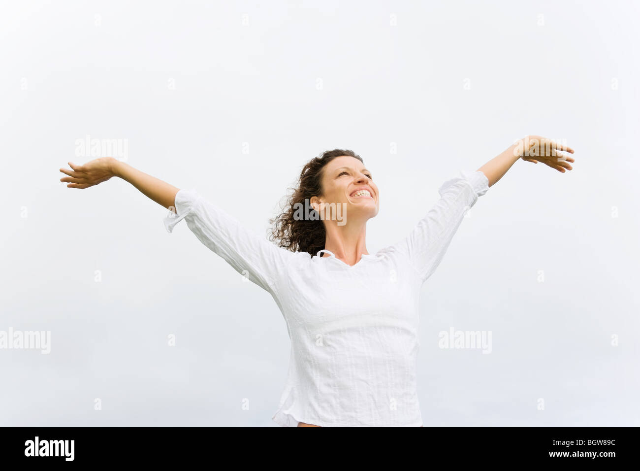 woman smiling and happy with arms outstretched enjoying free spirit ...