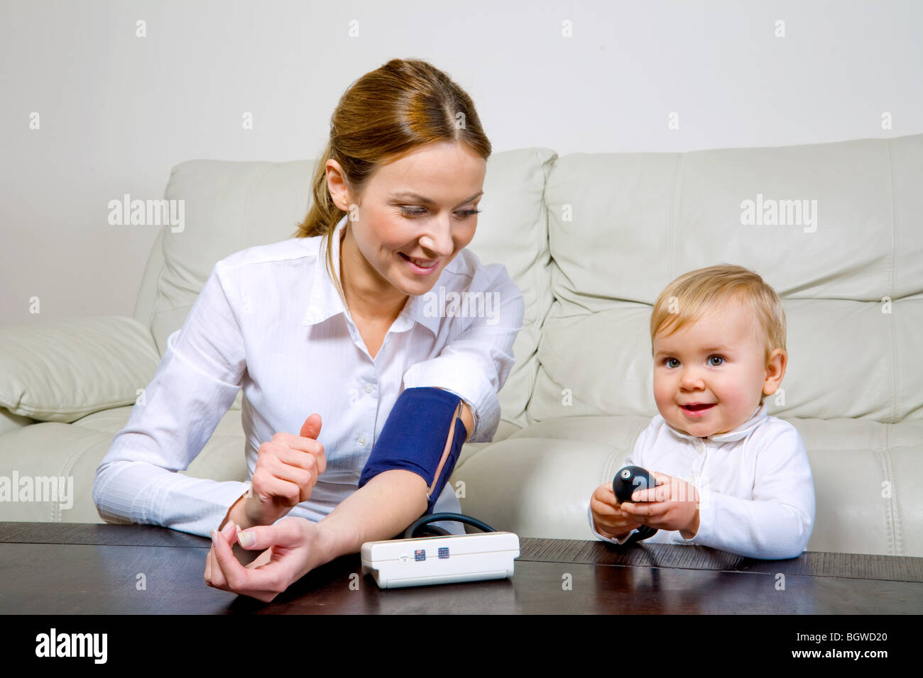 young woman and her baby with a blood pressure meter Stock Photo - Alamy