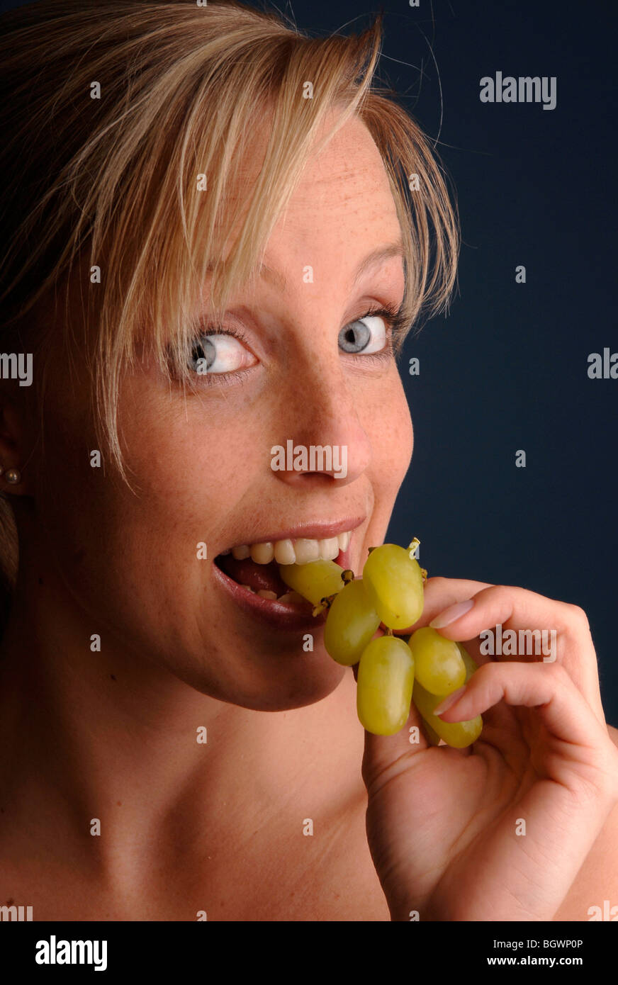 Young woman eating grapes Stock Photo - Alamy