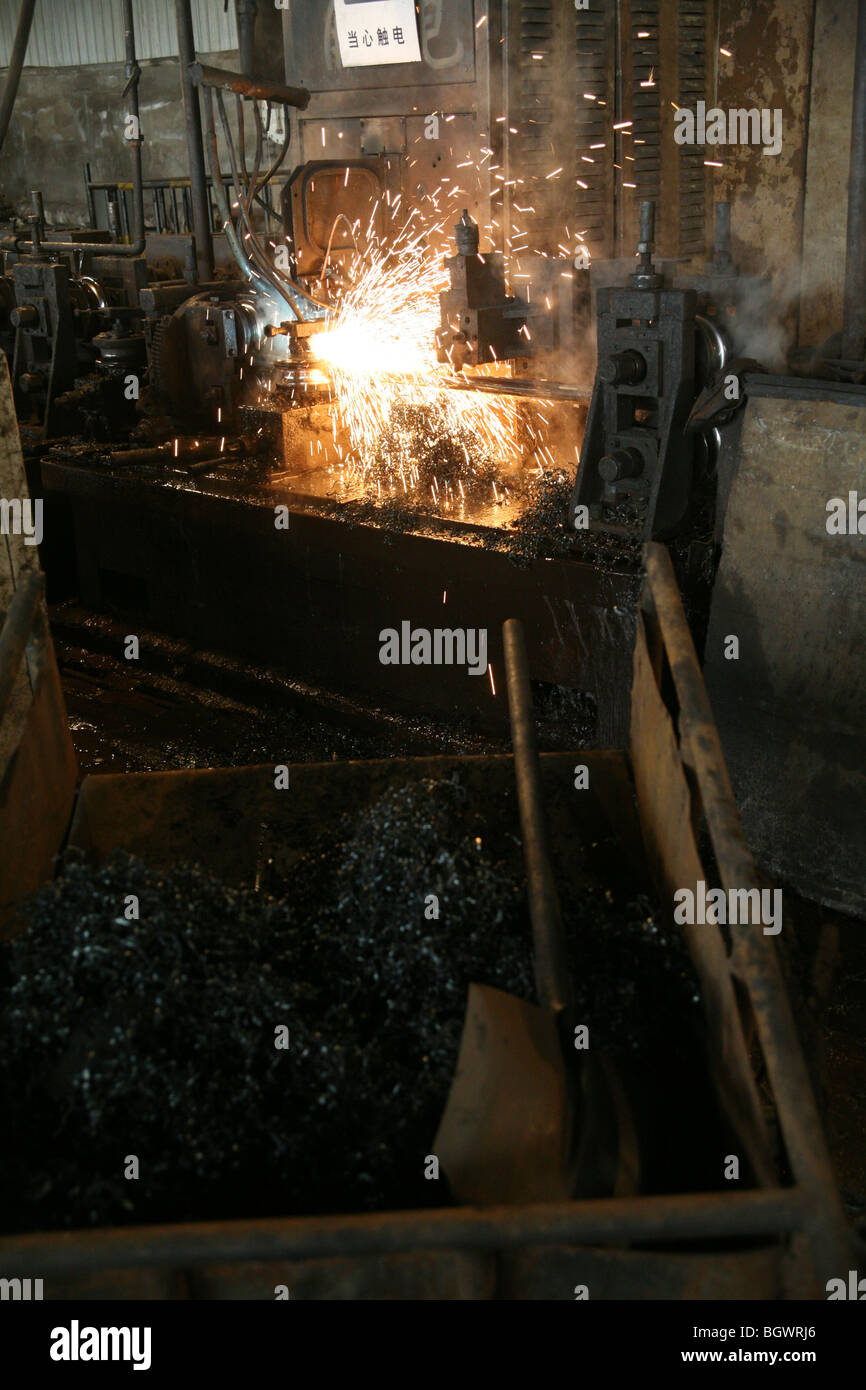 Sparks flying from steel tube welding machine, wheelbarrow and shovel ...