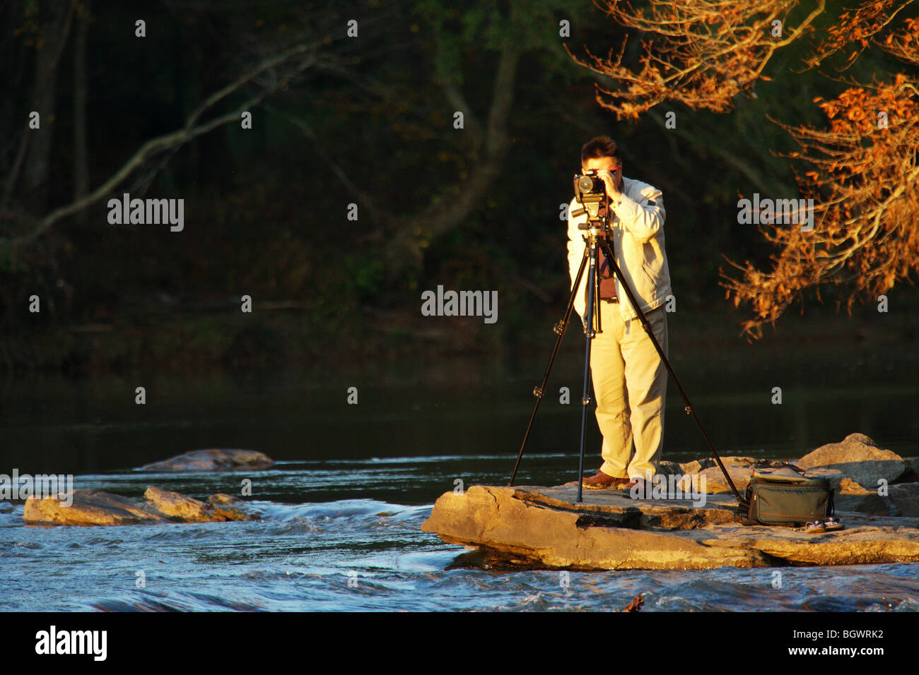 NATURE PHOTOGRAPHER SHOOTING ALONG RIVER IN GOLDEN LIGHT NO MODEL ...