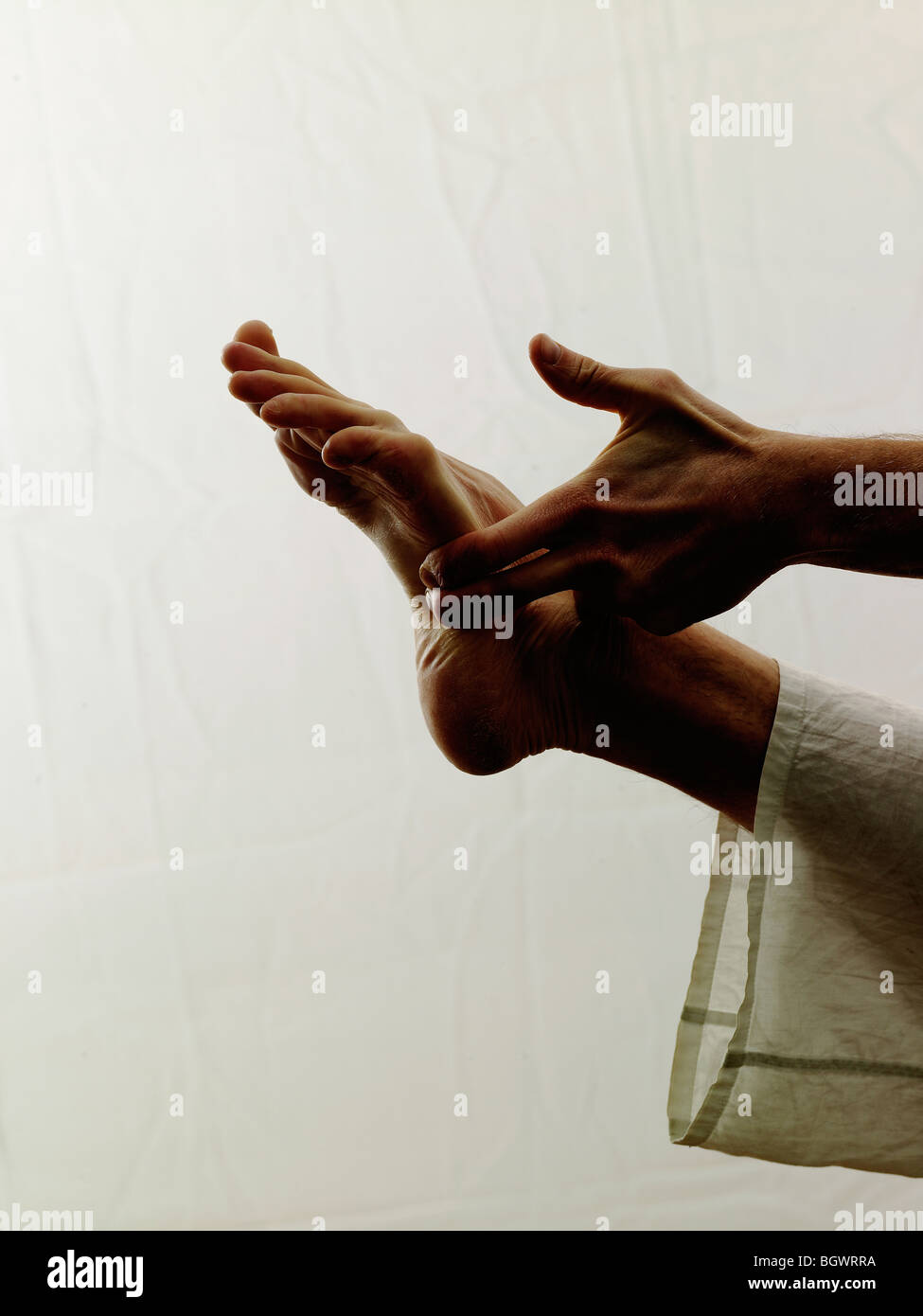 fingers holding foot in yoga pose Stock Photo - Alamy