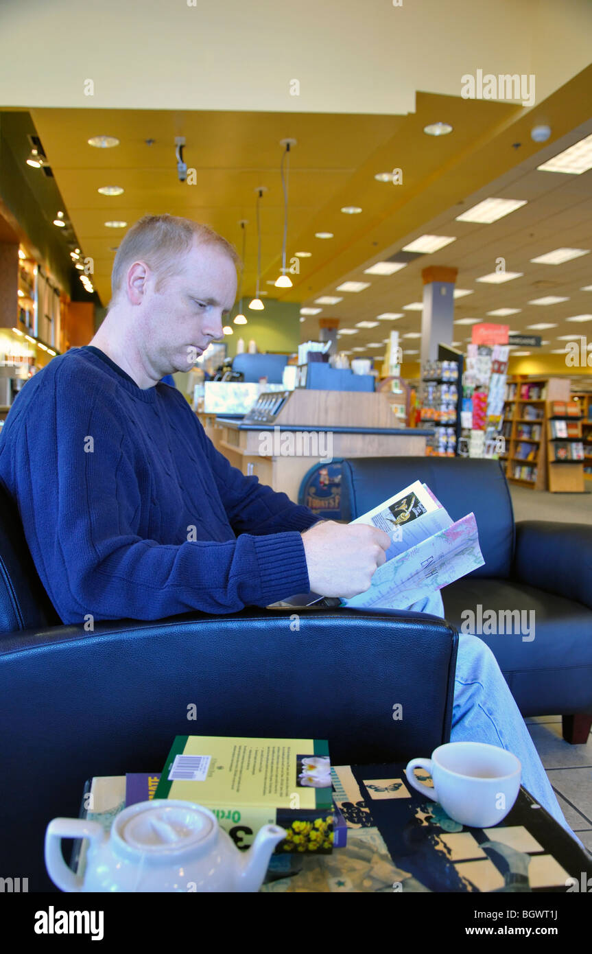 Man reading book in bookstore Stock Photo - Alamy