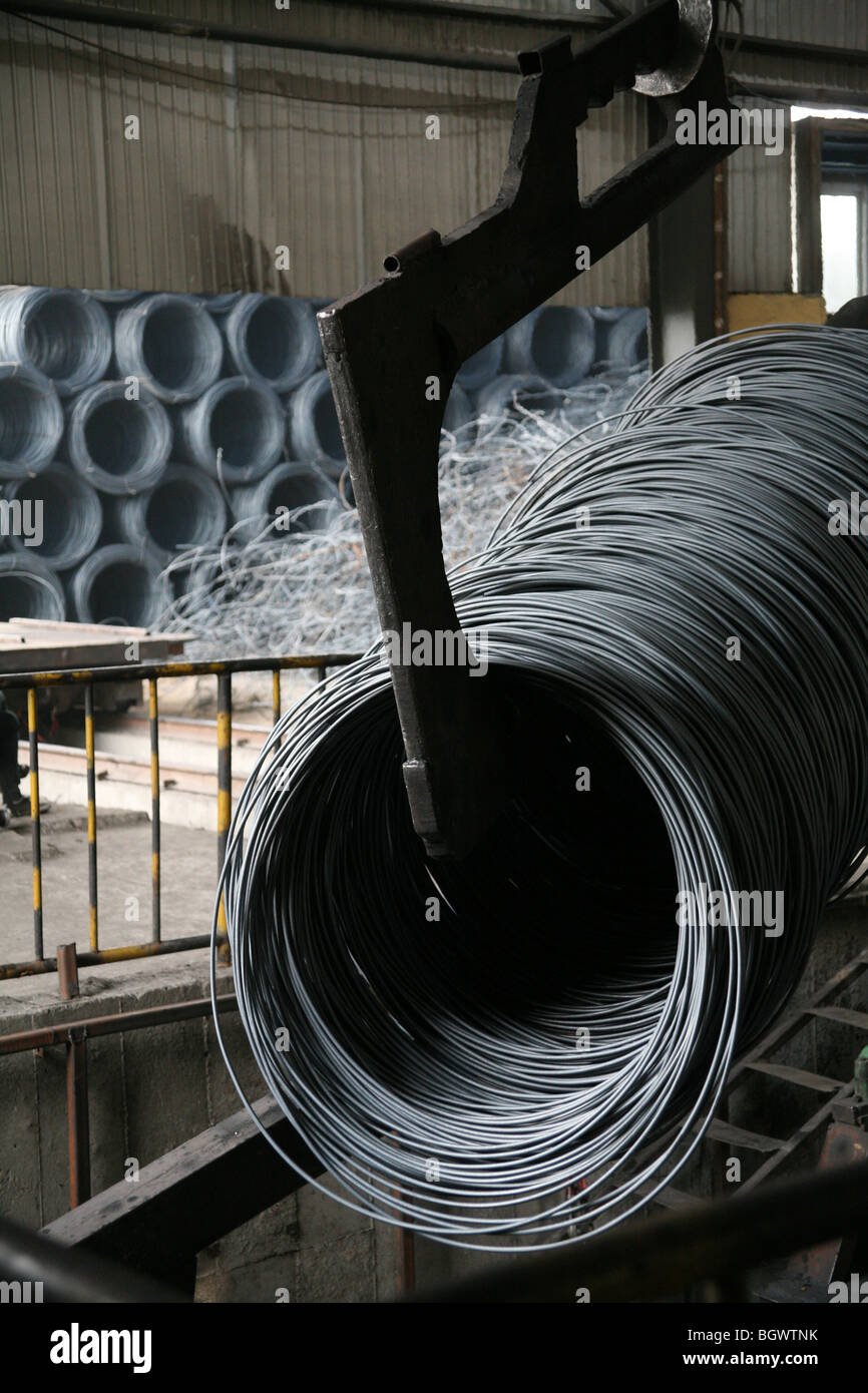 Crane hoisting steel wire rod, Chinese steel plant Stock Photo - Alamy