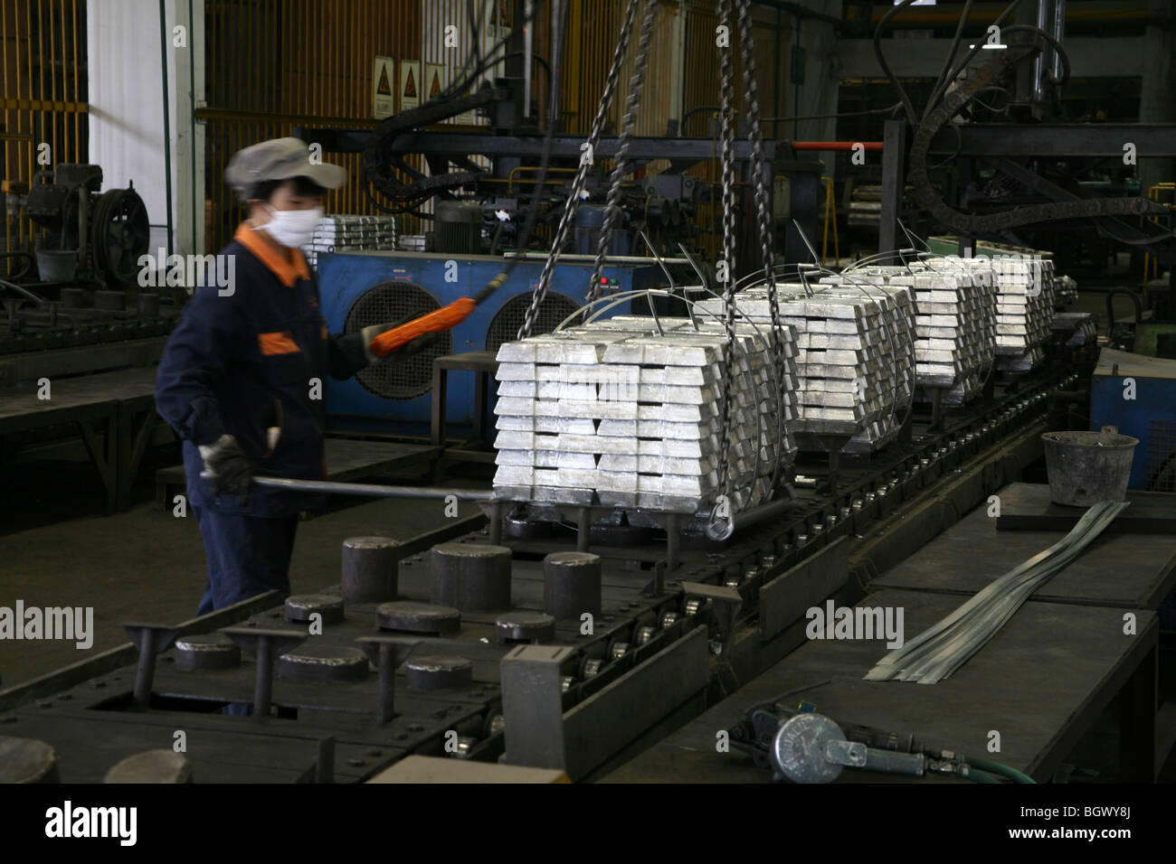 Chinese worker hoisting stack of zinc ingots Stock Photo - Alamy