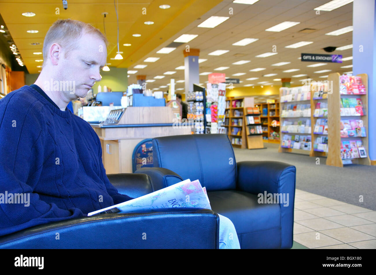 Man reading book in bookstore Stock Photo - Alamy