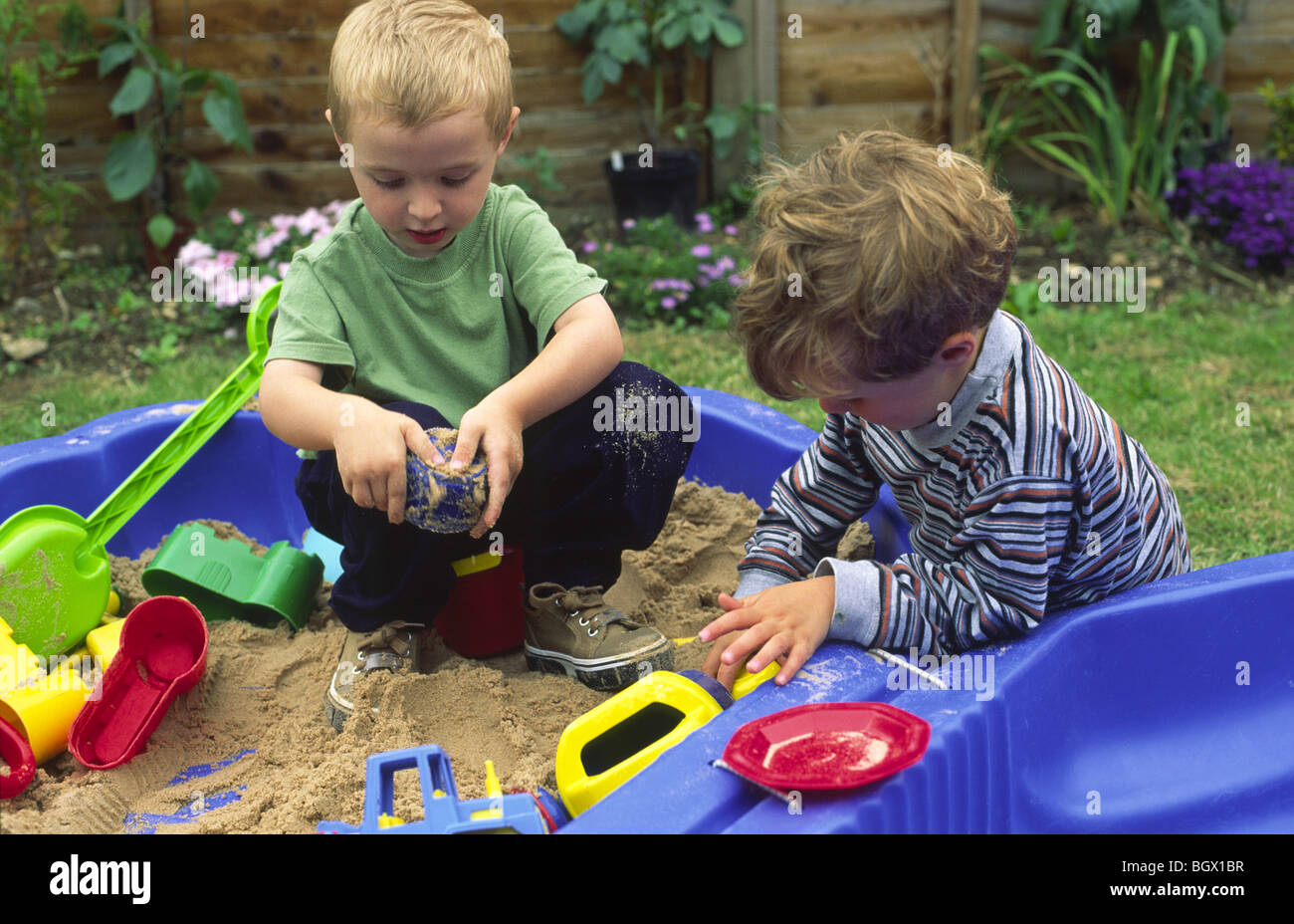 Three children playing in sand hi-res stock photography and images - Alamy