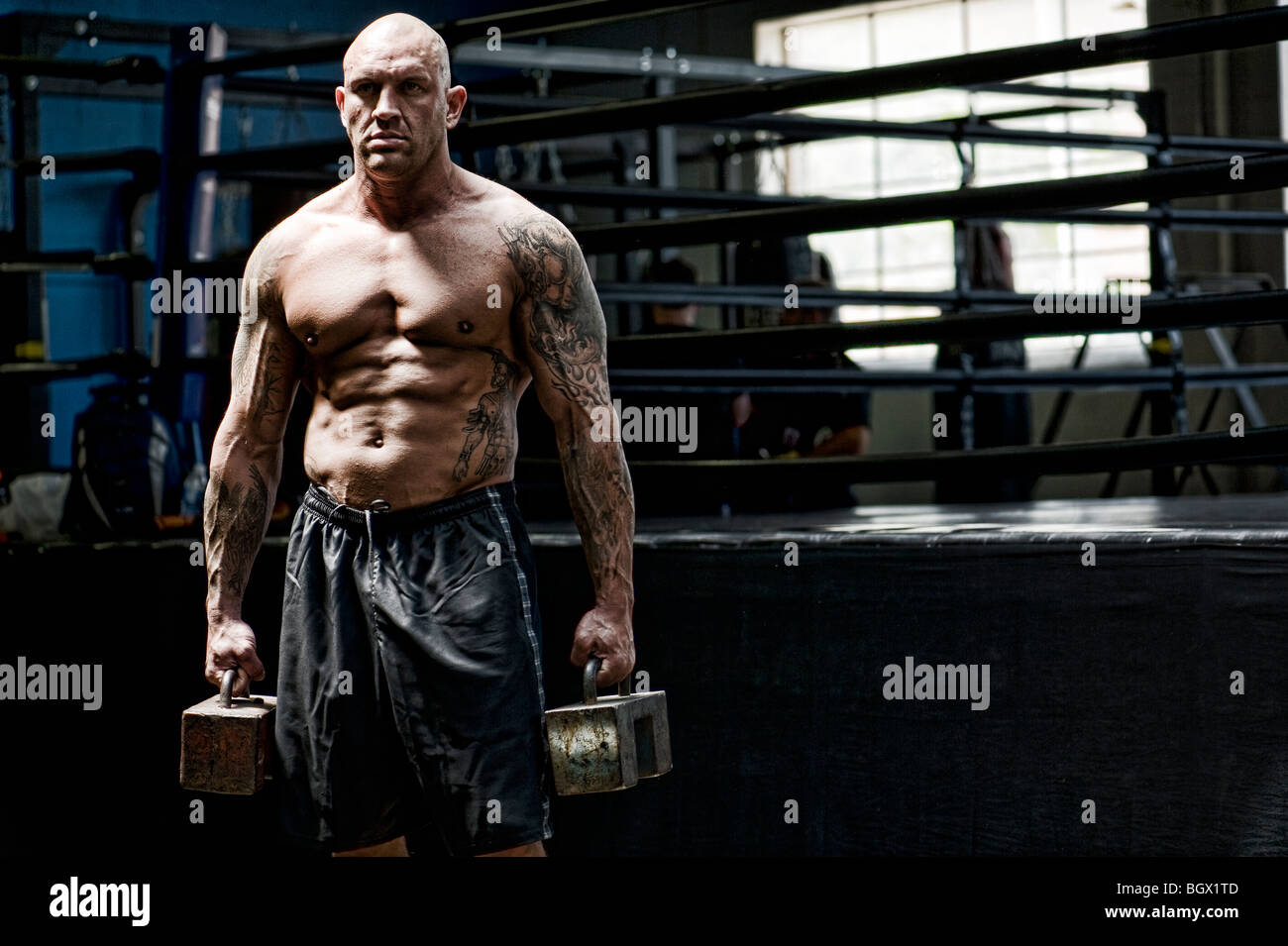 Ultimate fighter standing with weights Stock Photo - Alamy