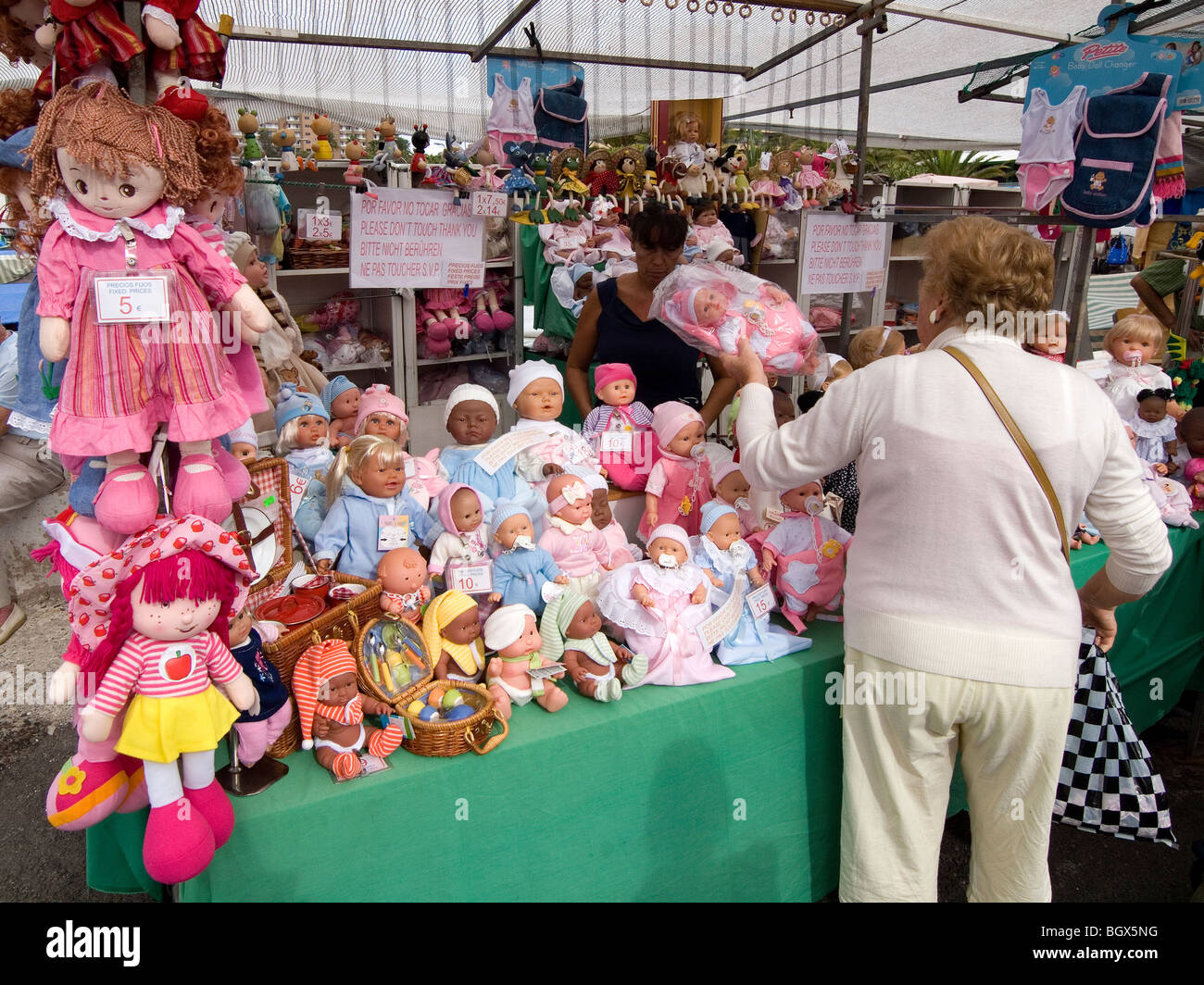 A woman buying a doll at the flea market in Los Cristianos, supposed to ...